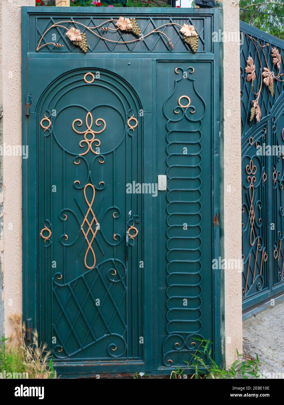 Dark turquoise iron gate with a wrought pattern with gilding Stock ...