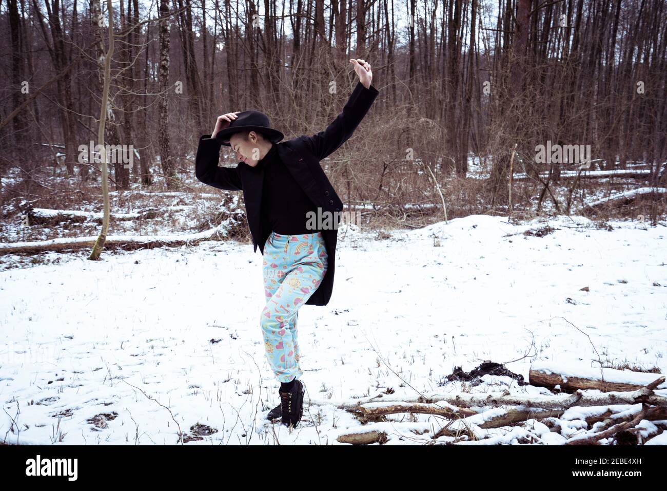 Androgynous dancer in bright blue pants dances in snow in Germany Stock ...