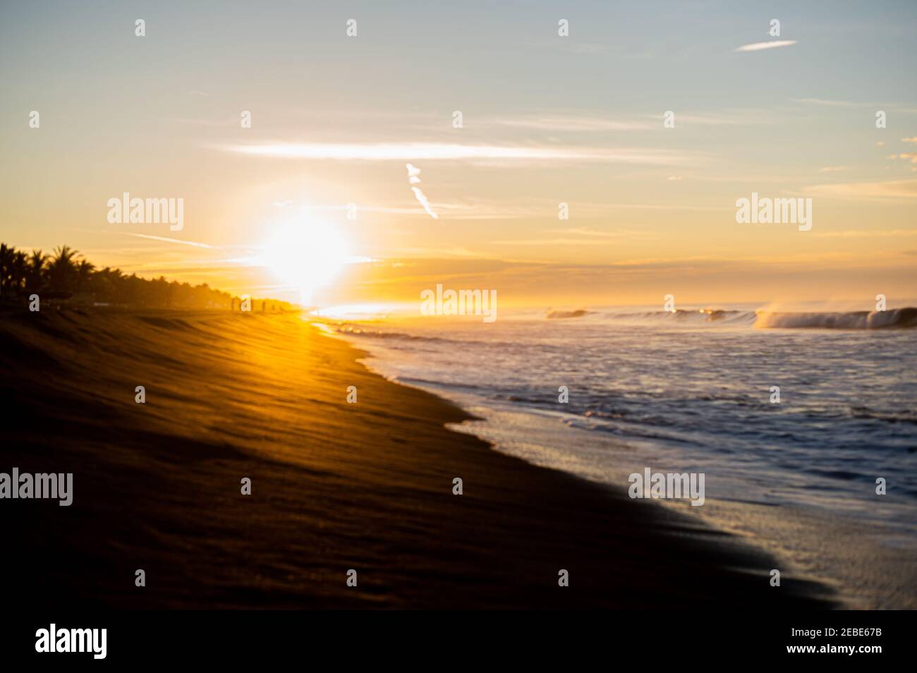 the sun rising and the waves on the beach Stock Photo - Alamy