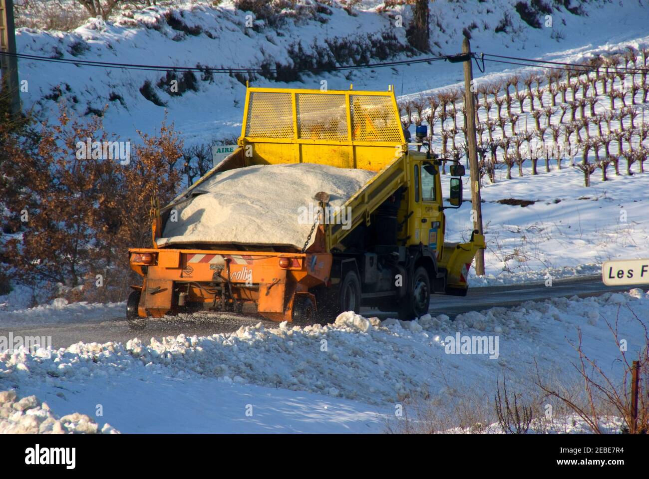 Gritter speading its load on a road between vineyards in the Languedoc ...