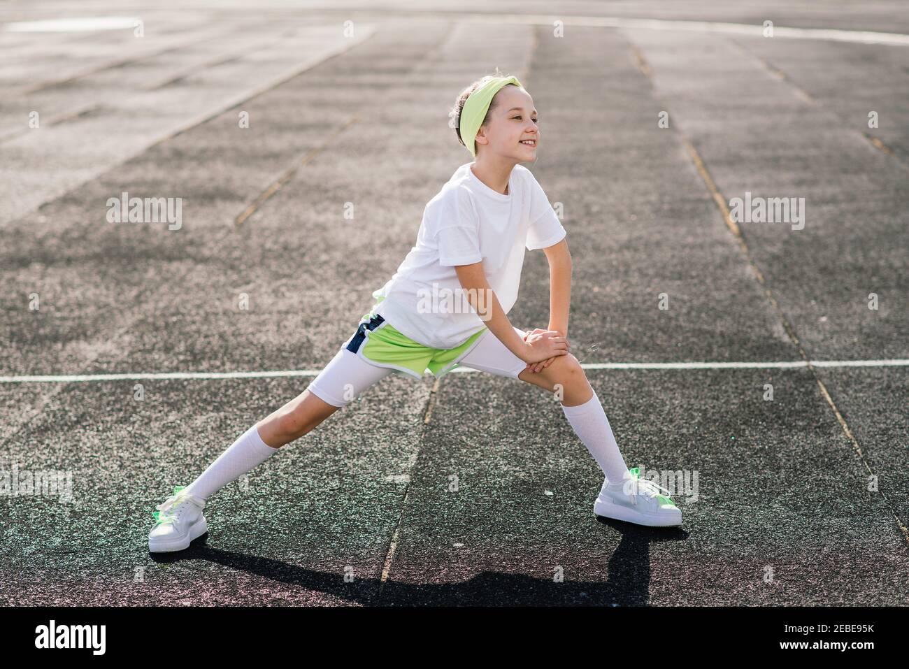 Girl jogging on a sunny summer evening, laying on treadmill, stadium ...