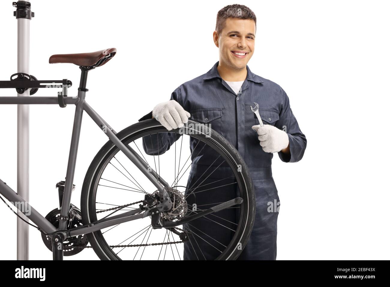 Bicycle repairman fixing a bicycle wheel with a wrench and smiling ...