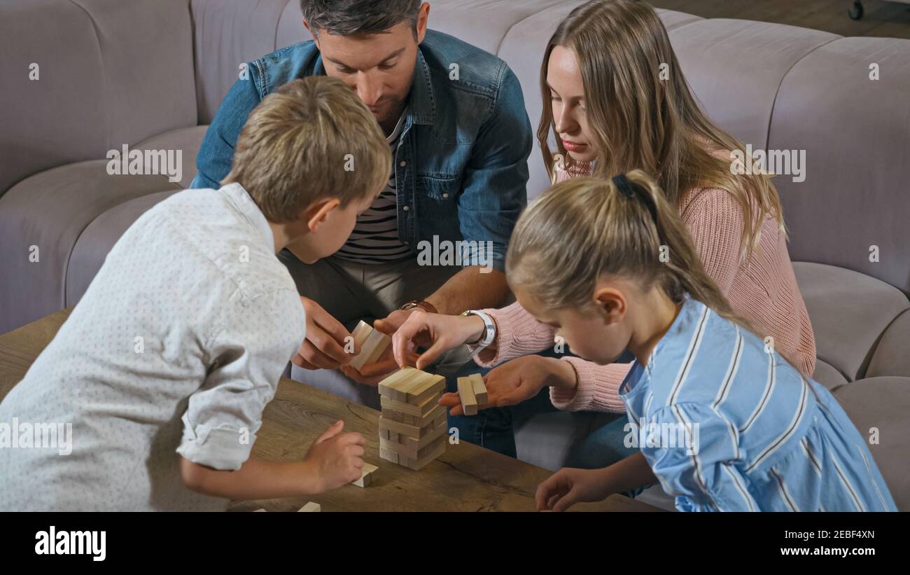 Family with kids playing wood blocks game at home Stock Photo - Alamy
