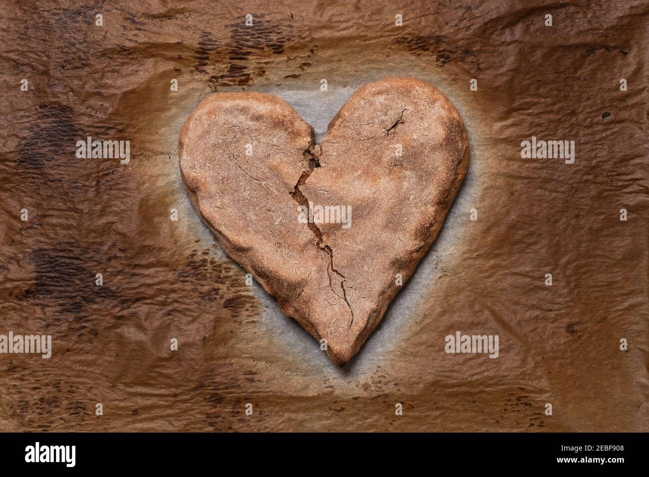 close up of a broken heart made from baked beard on paper. Symbol of ...