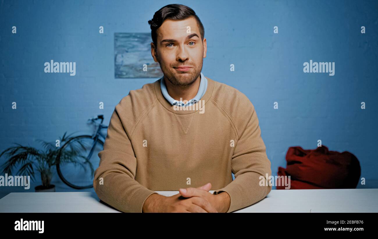 Skeptical man looking at camera at home Stock Photo - Alamy