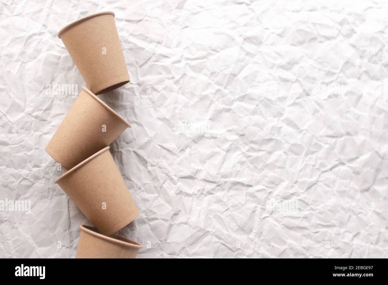 disposable kraft paper cups laid out on gray crumpled paper in ...