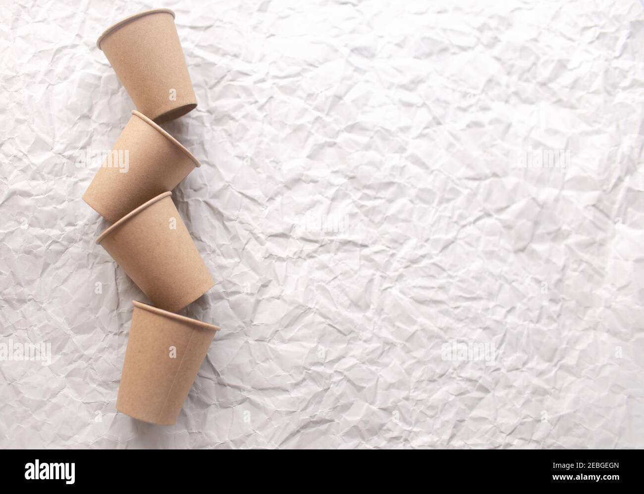 disposable kraft paper cups laid out on gray crumpled paper in ...