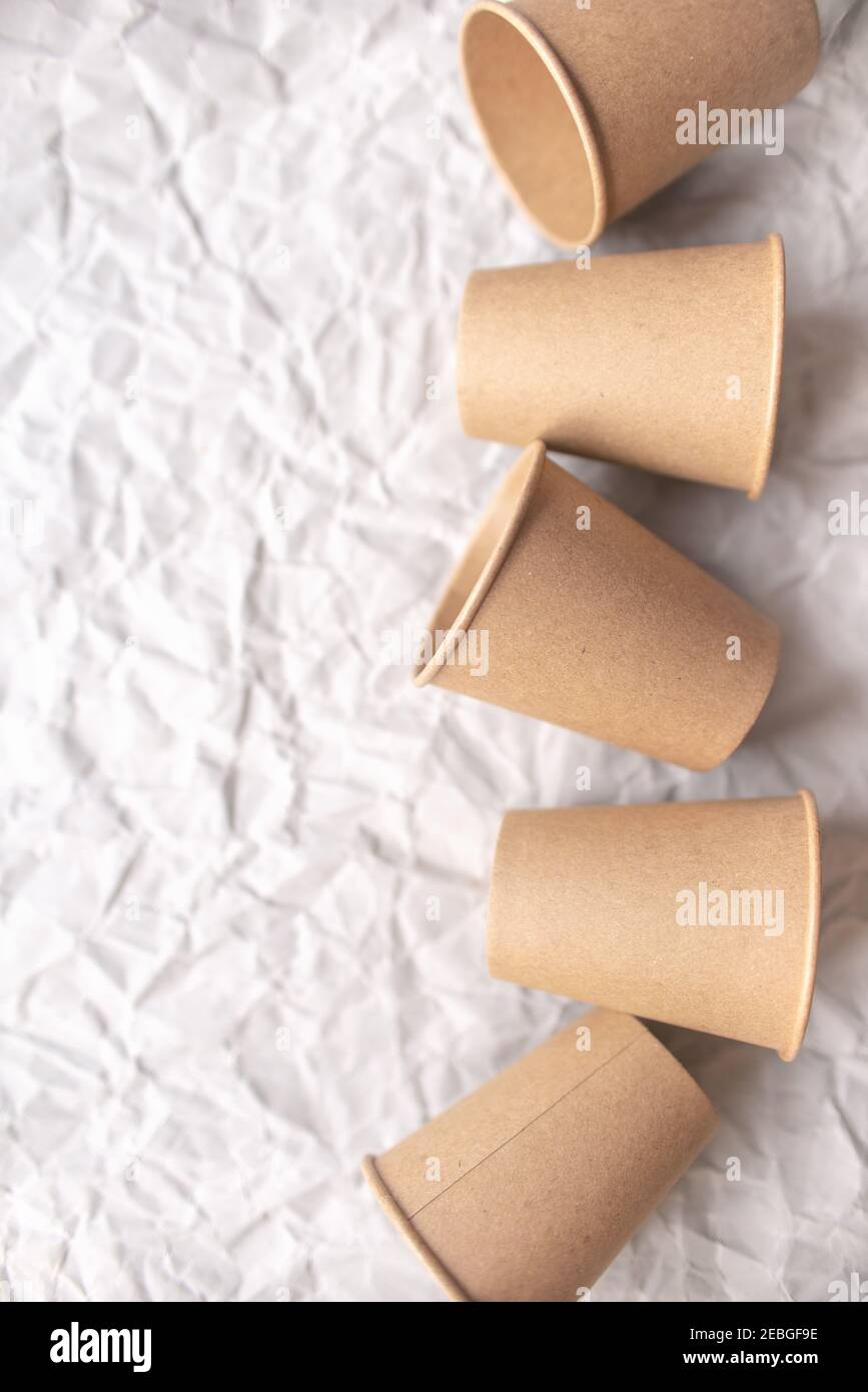 disposable kraft paper cups laid out on gray crumpled paper in ...