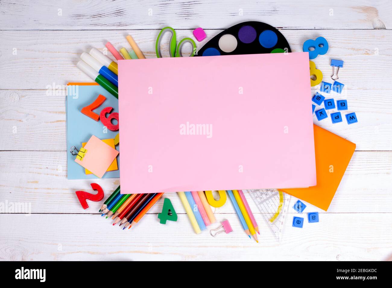 Pink paper blank and school supplies on white wooden background. Back ...