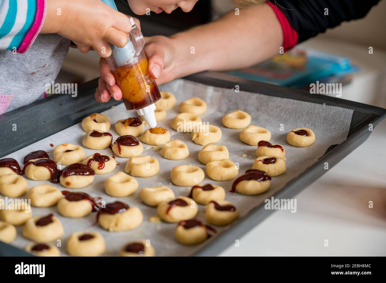 Cute blonde girl making cookies with her mother Stock Photo - Alamy