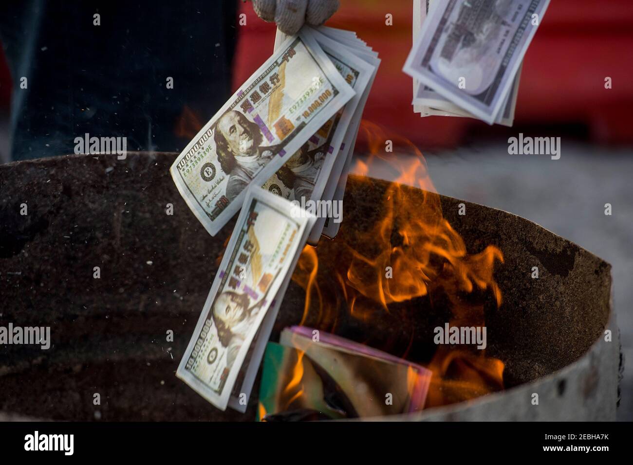 A worshipper seen burning paper money to ancestors outside the temple ...