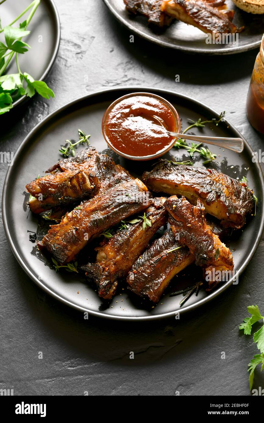 Grilled spare ribs on plate over black stone background Stock Photo - Alamy