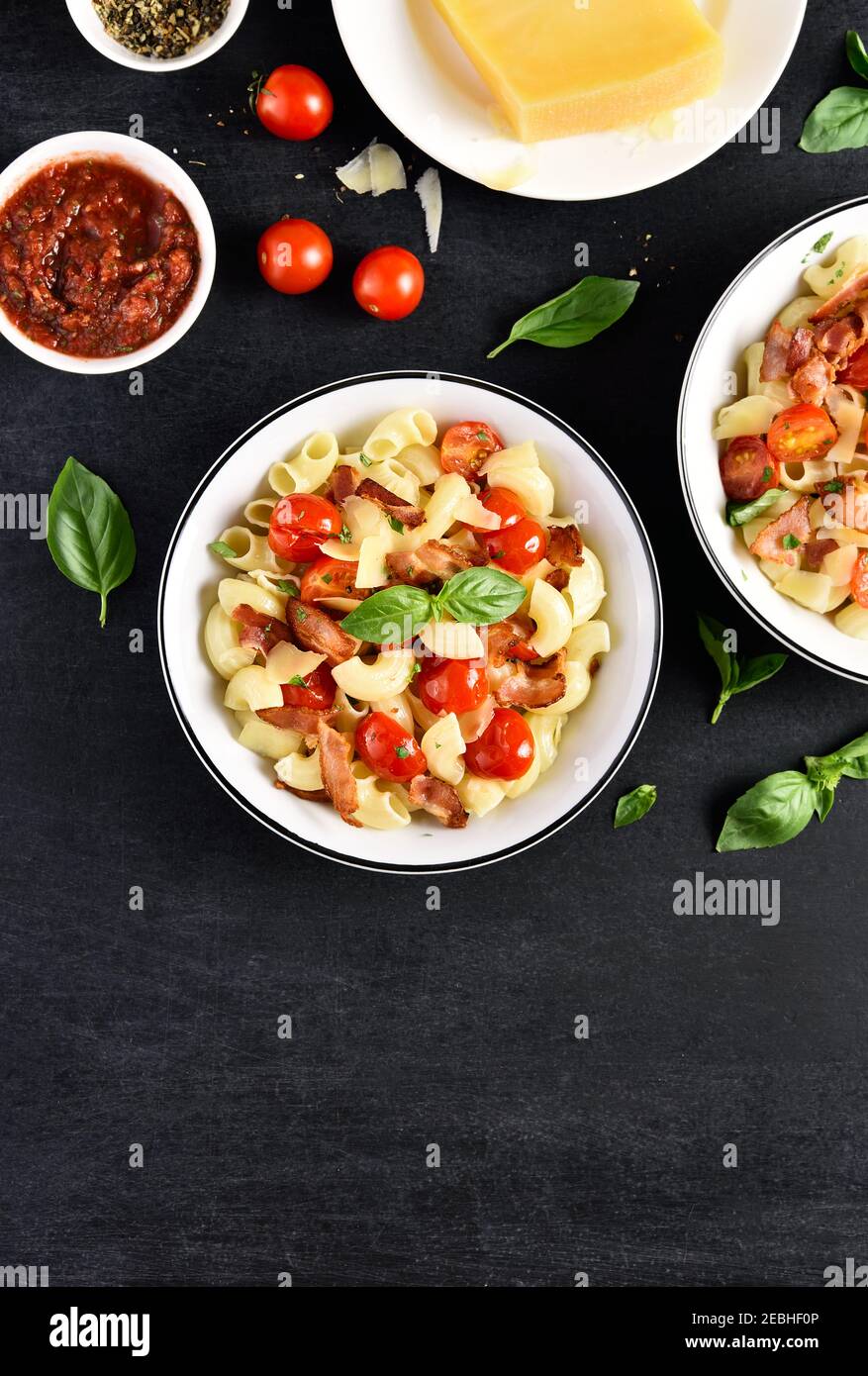 Pasta with bacon, tomato, parmesan cheese and basil leaves on plate ...