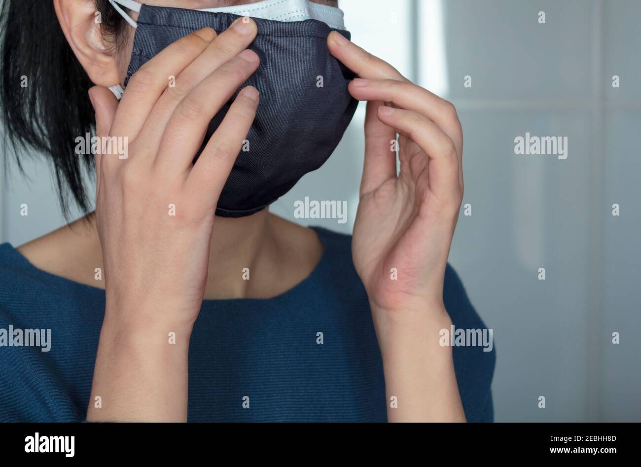 Woman using two face masks at the same time Stock Photo - Alamy