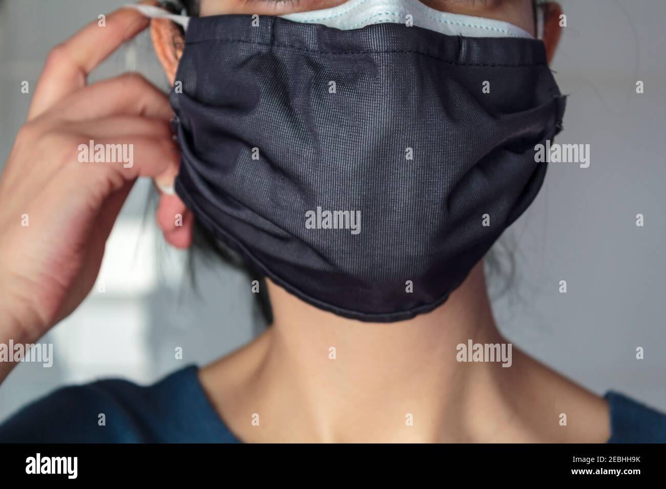 Woman using two face masks at the same time Stock Photo - Alamy