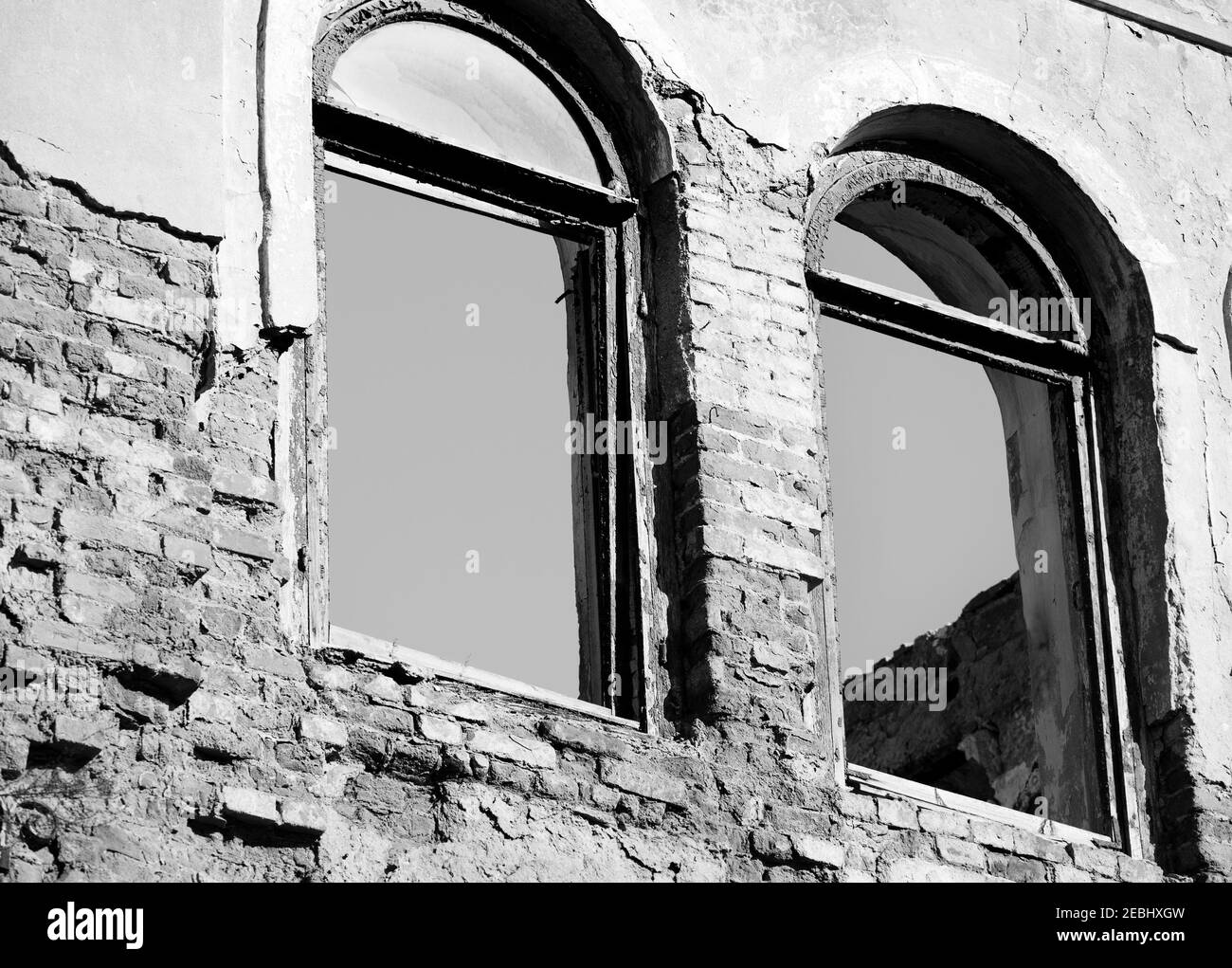 Brick wall of old destroyed house with broken windows. Black and white toned image Stock Photo ...