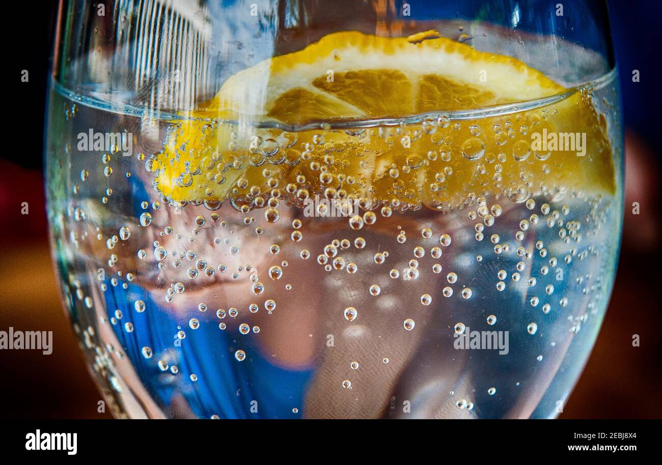 Cold refreshing drink in a glass with sparkling water, ice and lemon ...