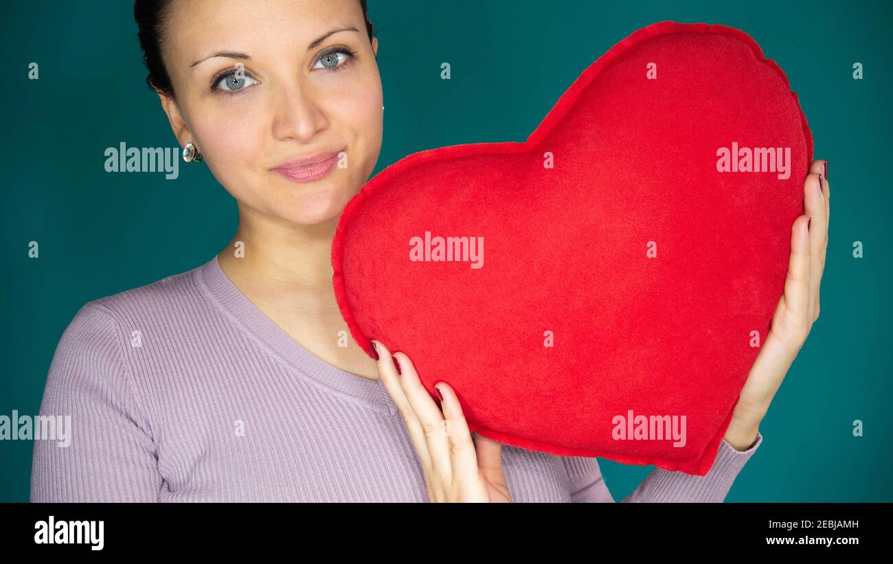 A portrait of a woman giving love holding a big red heart Stock Photo ...
