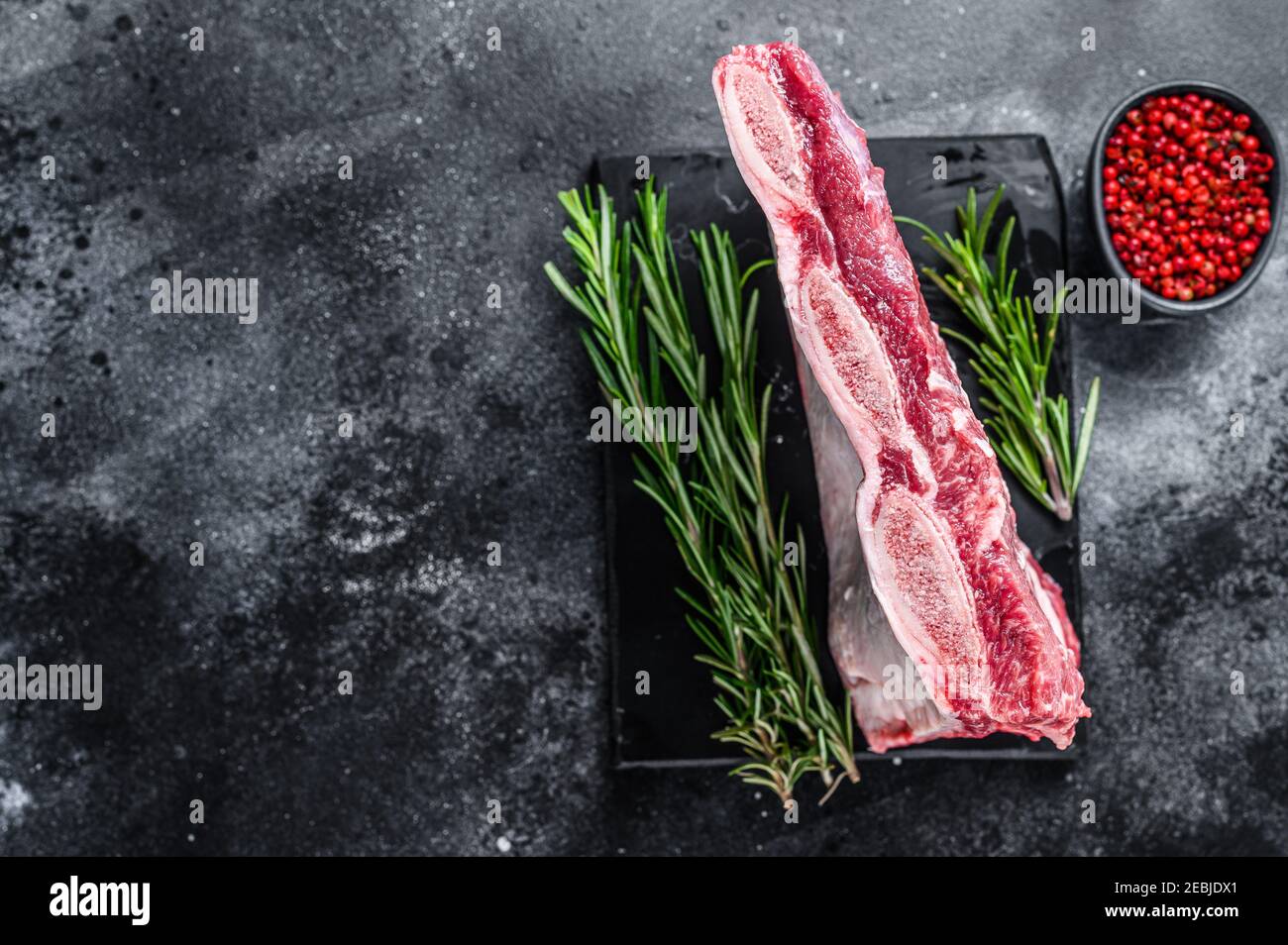 Raw beef short ribs kalbi on marble board. Black background. Top view ...