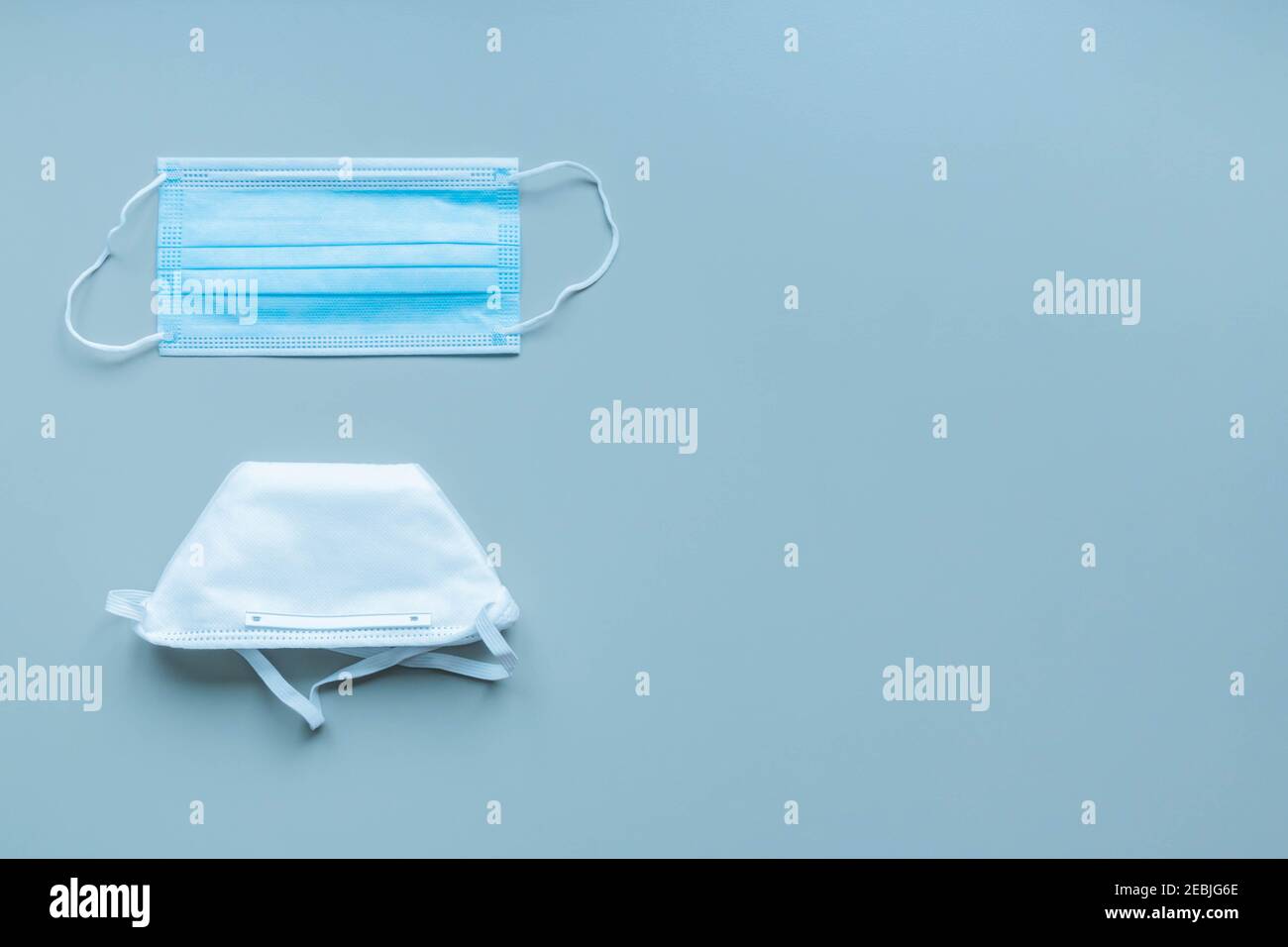 Disposable medical mask and disposable respirator on blue background ...