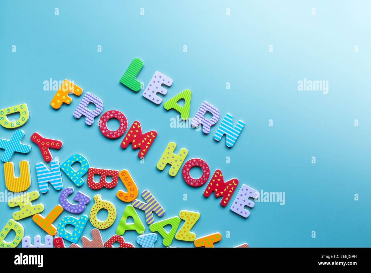 Words LEARN FROM HOME of colorful wooden letters and scattered letters ...