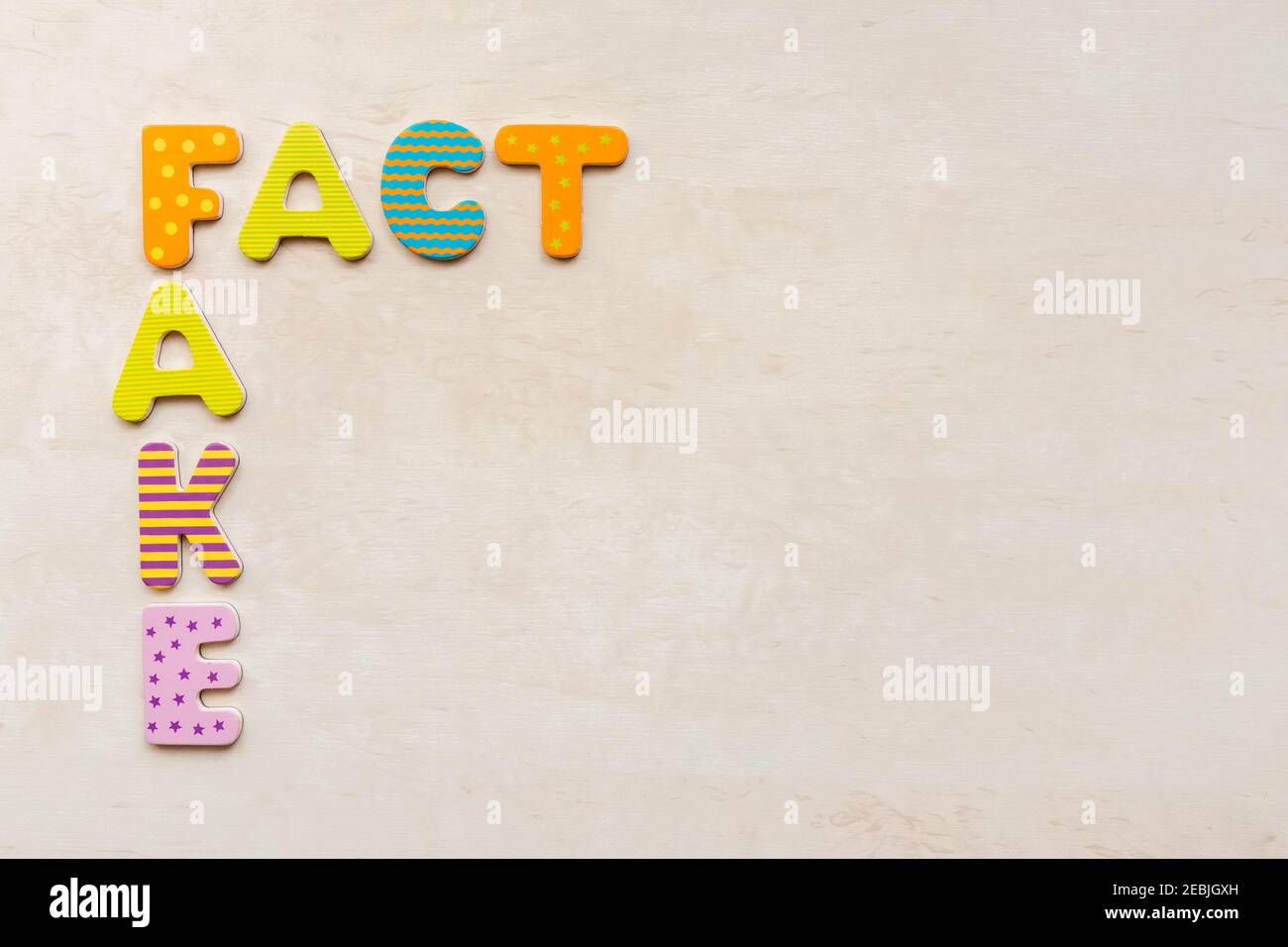 Composition with words FACT and FAKE of colorful wooden letters on ...