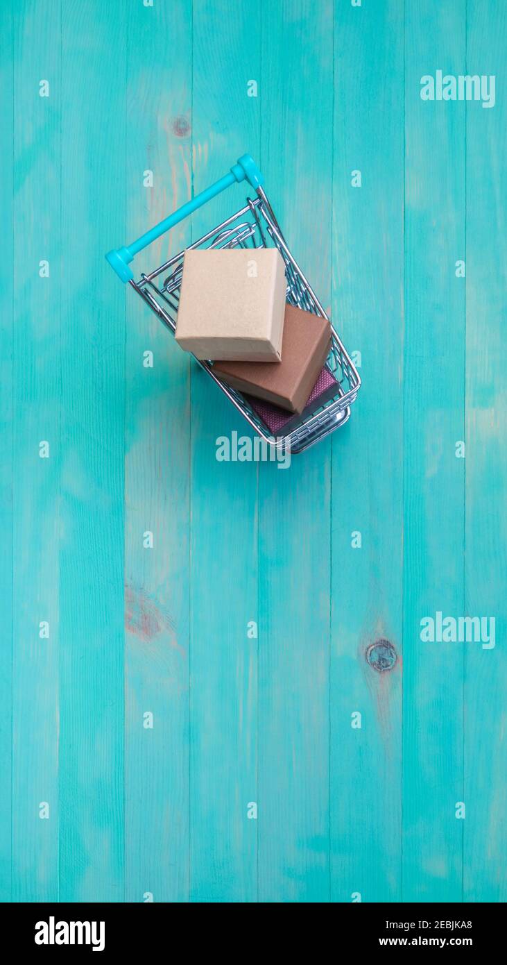 Shopping cart filled with boxes on vintage azure wooden background ...