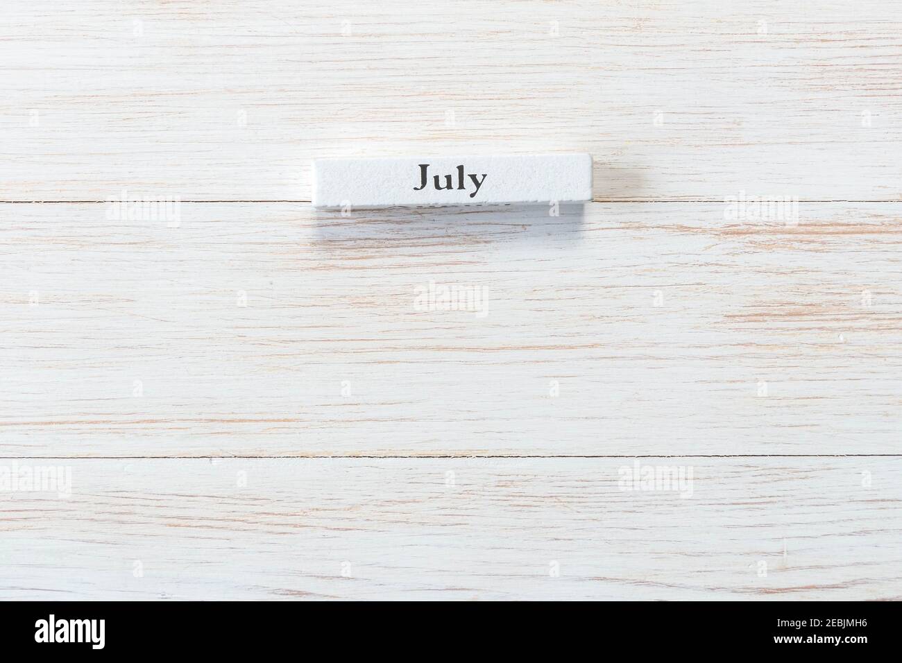 Whine wooden block of calendar with month July on vintage background ...