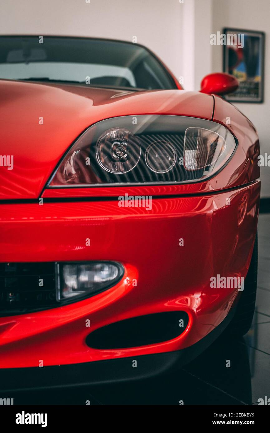 Vertical shot of a headlight of a red sportscar Stock Photo - Alamy