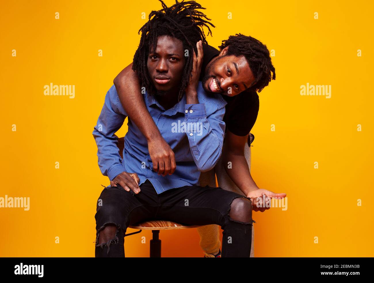 two african american guys posing cheerful together on yellow background ...