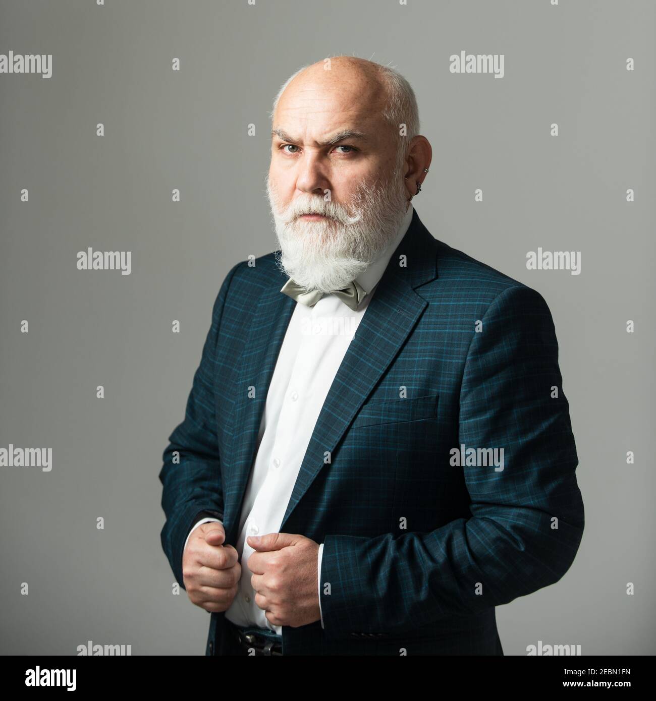 Serious Senior. Confident senior bearded man in a suit and tie stand on ...