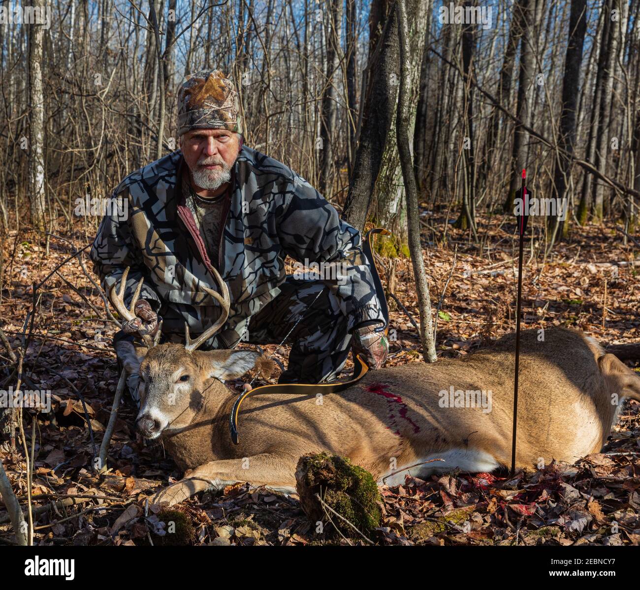 Hunter poses with his custom-made recurve bow and arrow and his ...