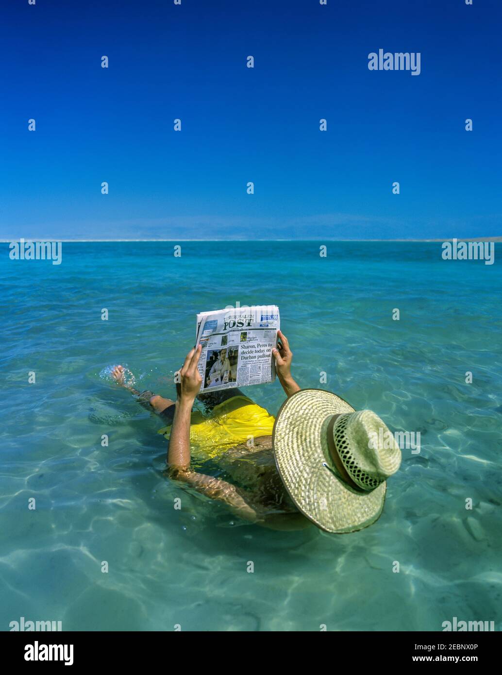 2001 HISTORICAL FLOATING MAN READING ENGLISH LANGUAGE NEWSPAPER EIN BOKEK DEAD SEA ISRAEL Stock ...