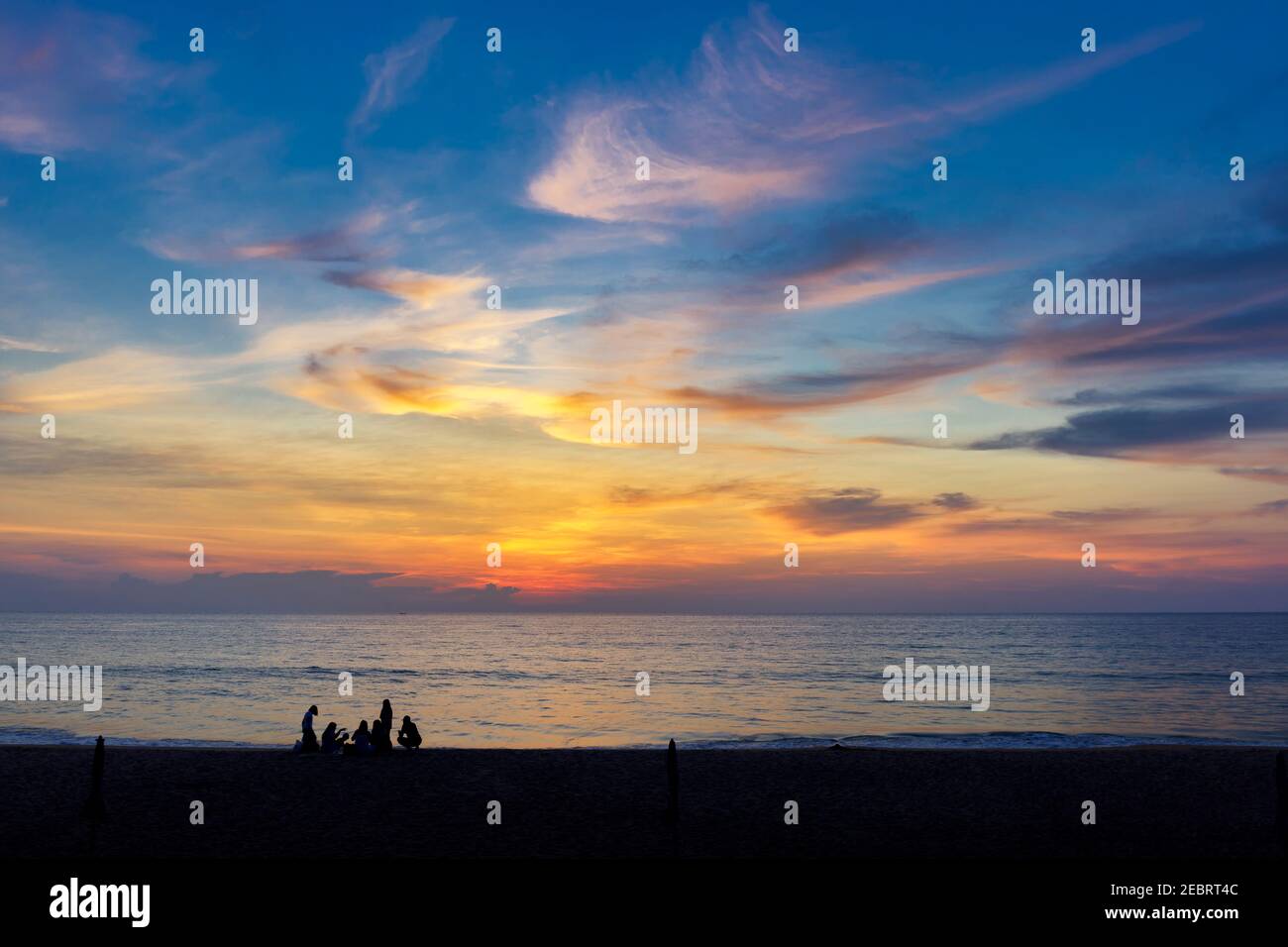 Silhouettes of group of people during the sunset in Seaside beach ...