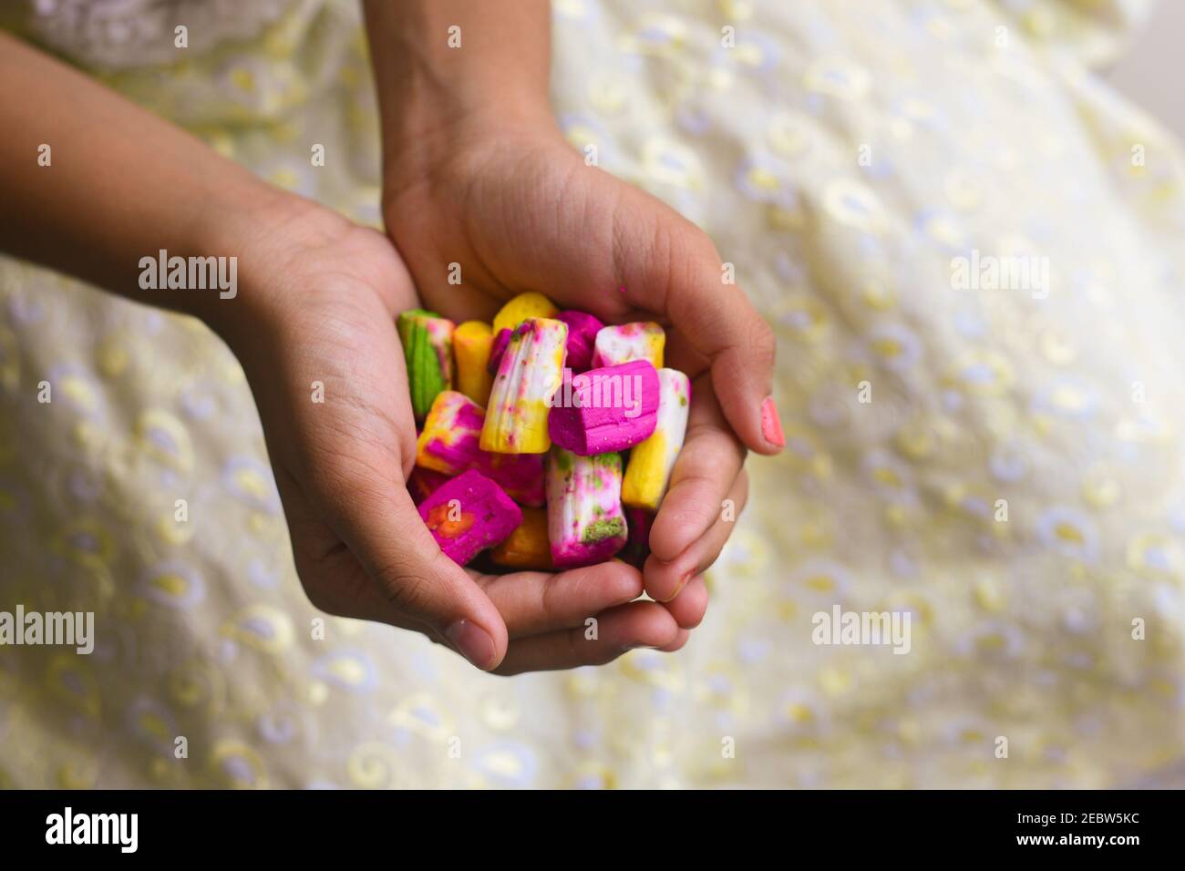 Girl hand taking and eating colorful array of different childs sweets ...