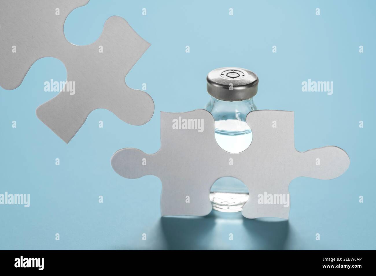 Vial of Covid-19 vaccine behind jigsaw puzzles Stock Photo - Alamy