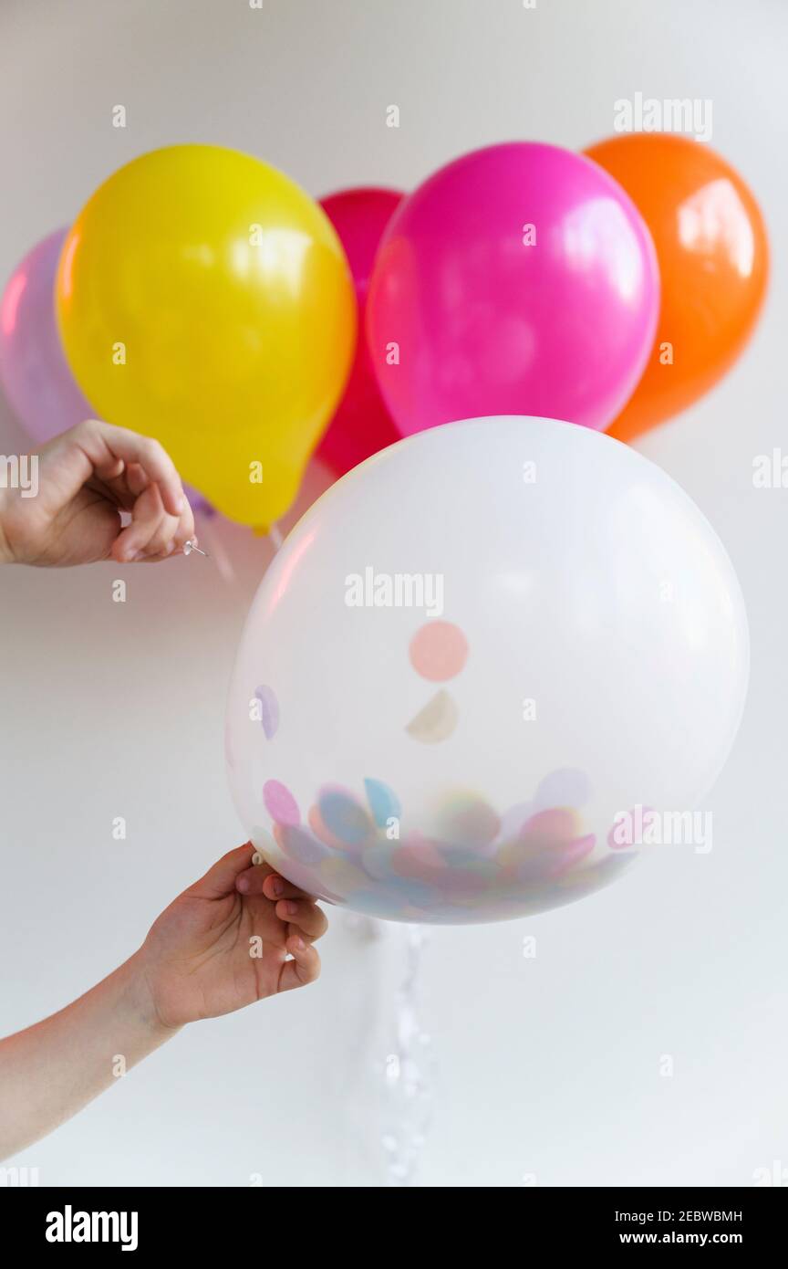 Hand holding bunch of colorful balloons Stock Photo - Alamy