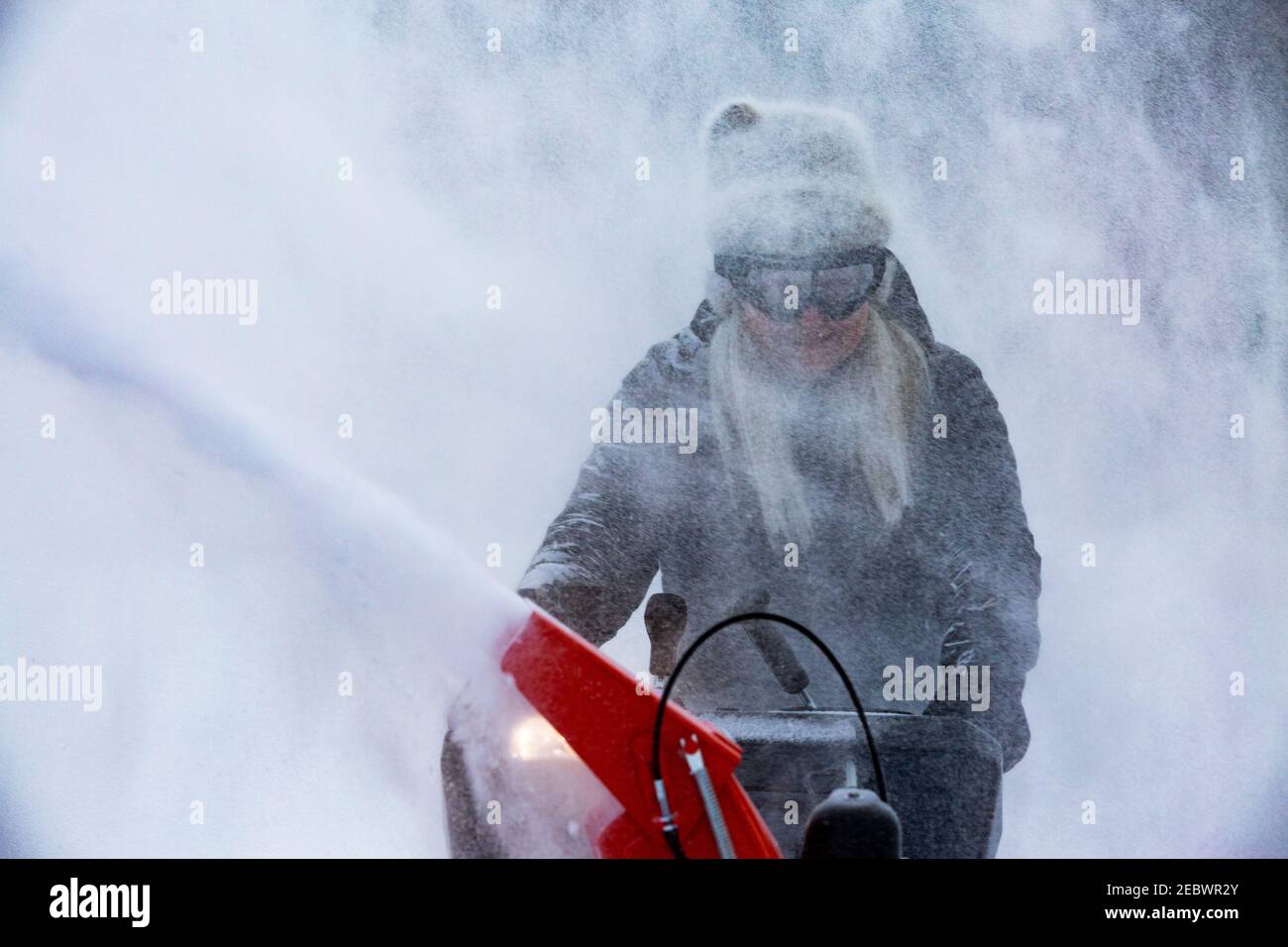 Senior woman clearing snow using snowblower Stock Photo - Alamy