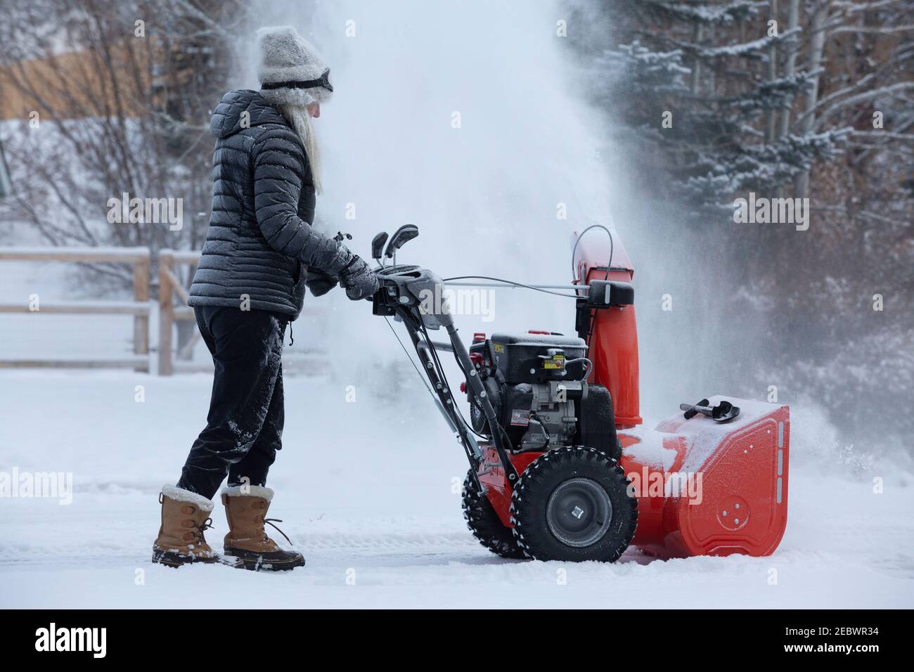 Senior woman clearing snow using snowblower Stock Photo - Alamy