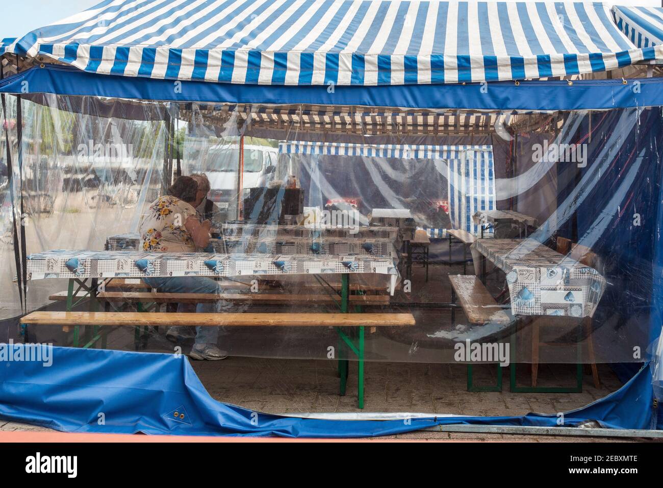 People having a cup of coffee in a coffee tent at the Market square of ...