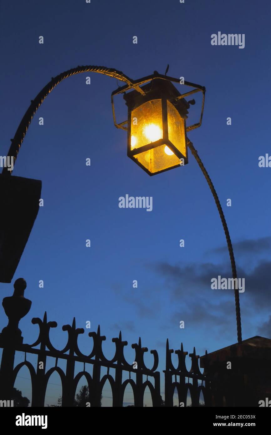 Metal gate with lamp hanging from the arch at sunset Stock Photo - Alamy