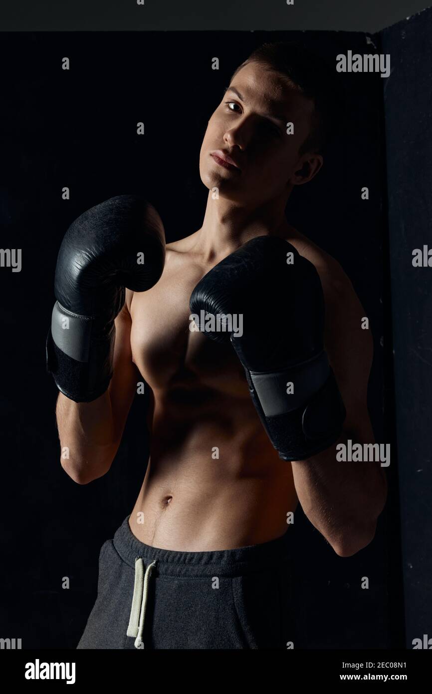 athlete in boxing gloves on black background portrait cropped view ...