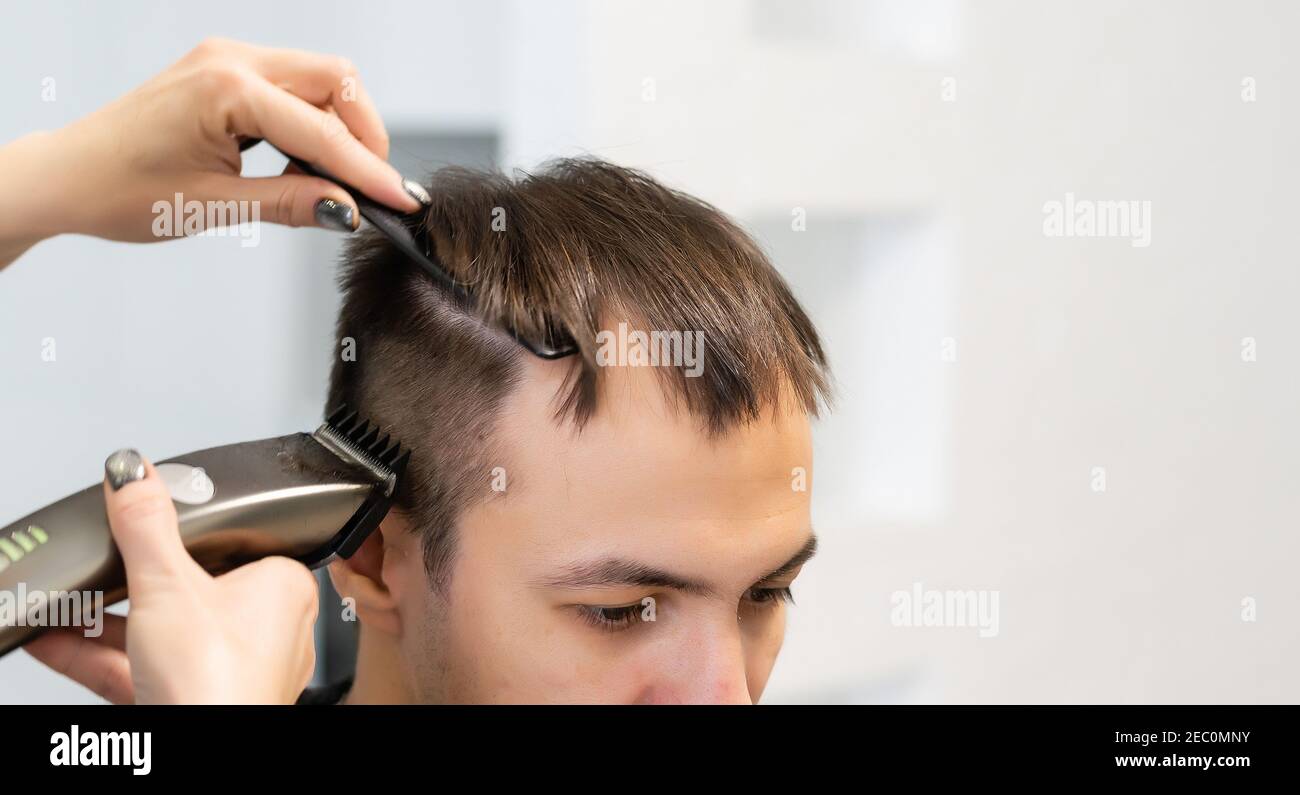 Barber cutting hair with clipper Stock Photo - Alamy