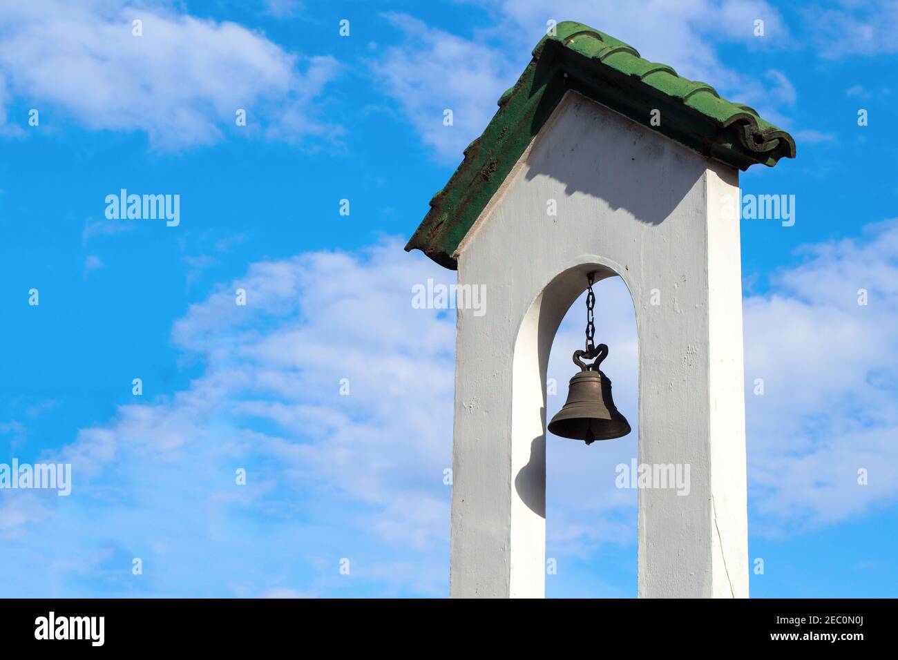 Churchbell in white wall of church tower. Catholic church building ...