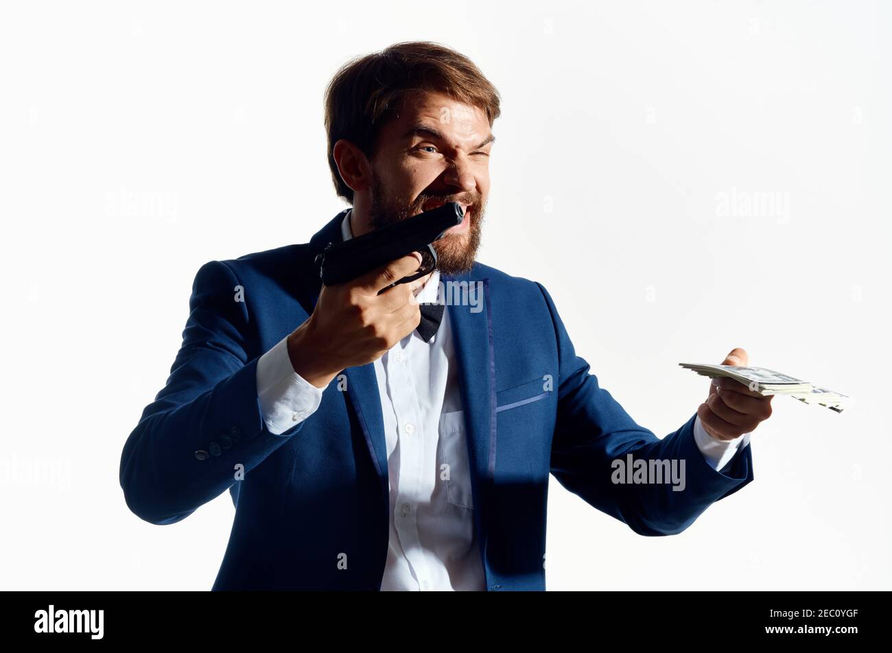male gangster with a wad of money and a gun in hand in a classic ...