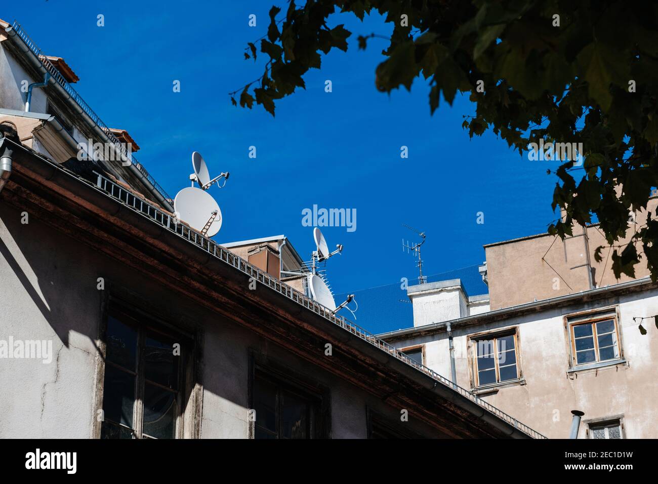 French rooftops with traditional windows on multiple satellite dishes ...