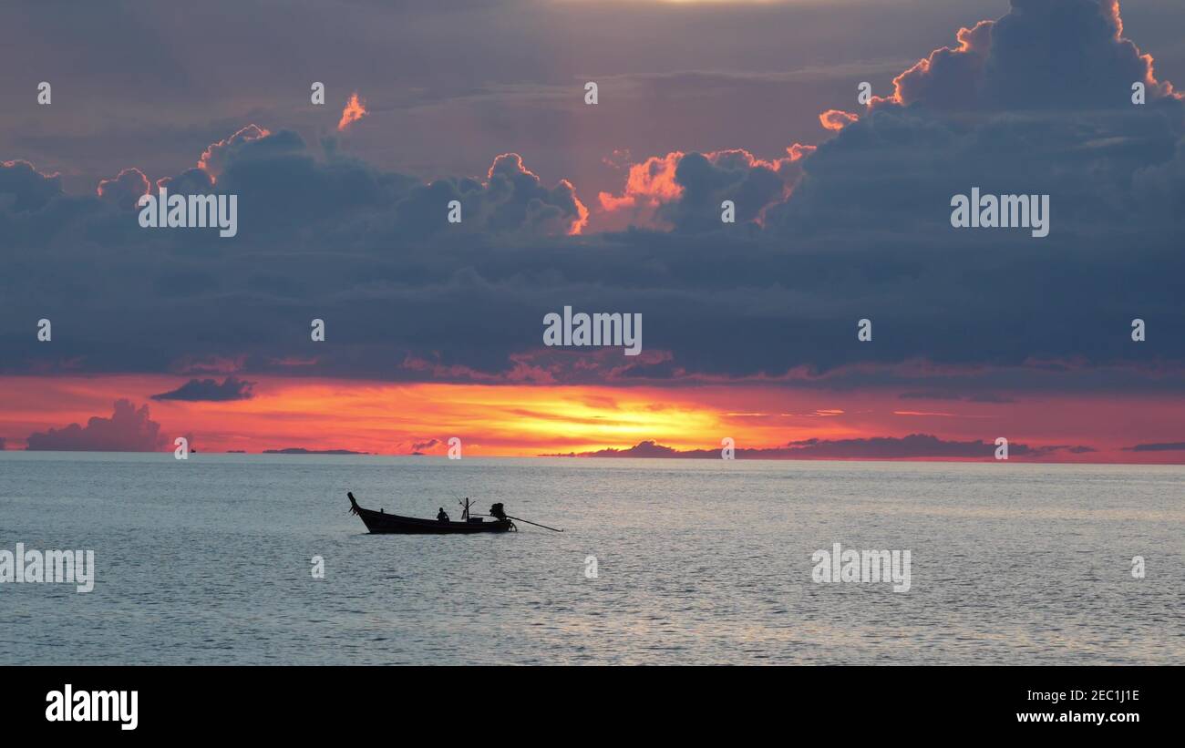 Boat in sea during sunset. Silhouette of small rowing boat floating on ...