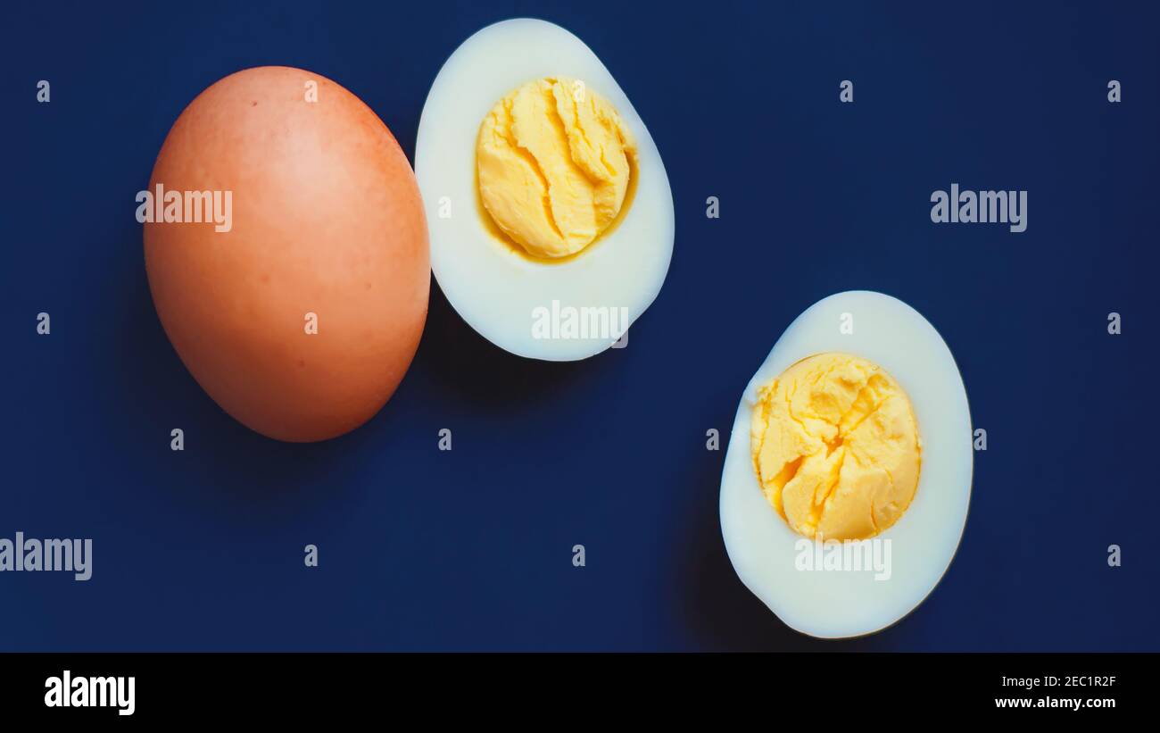 Top view of two boiled eggs, one egg still in the shell, and the other ...