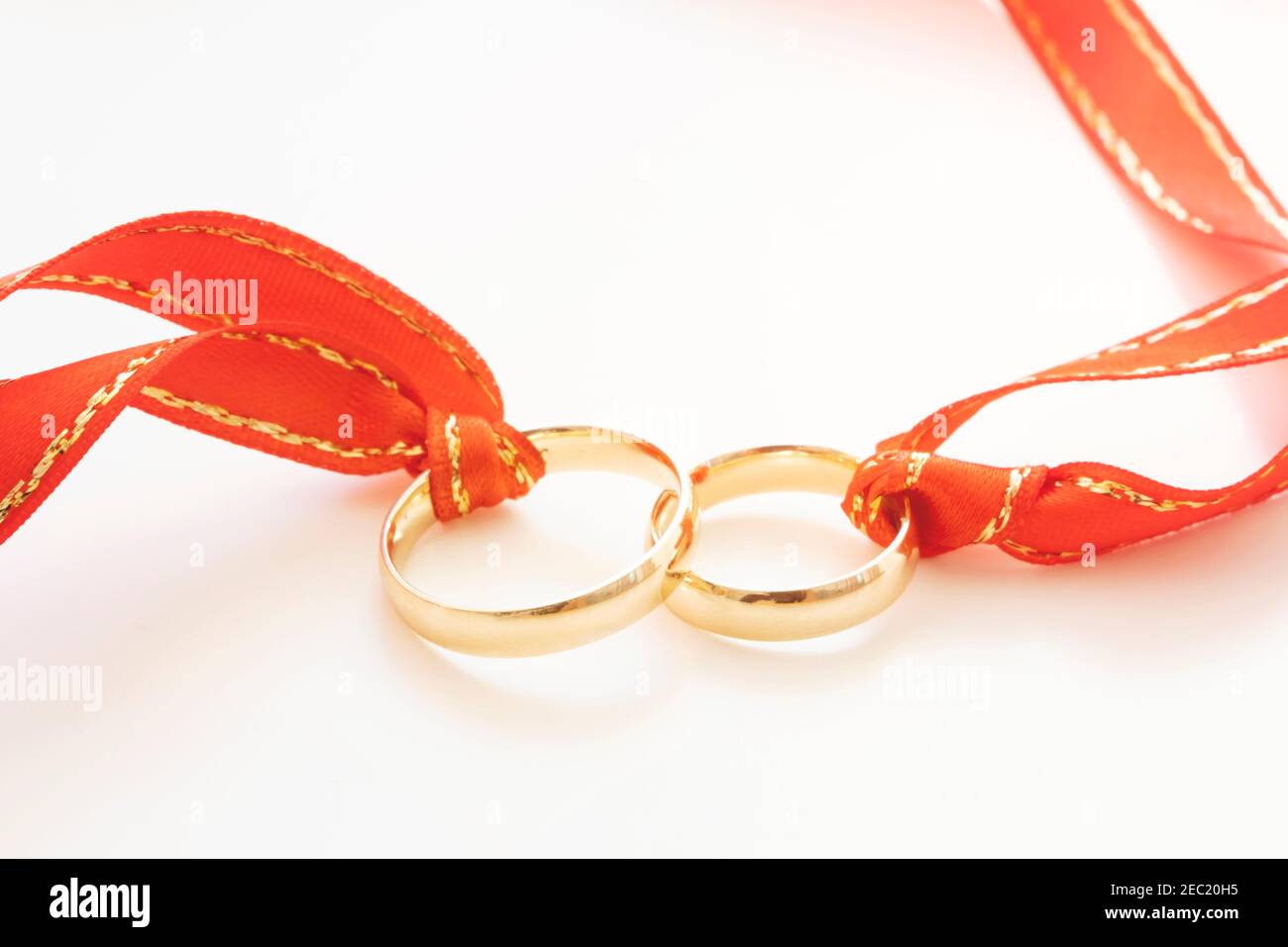 wedding rings and red ribbon on white background Stock Photo - Alamy