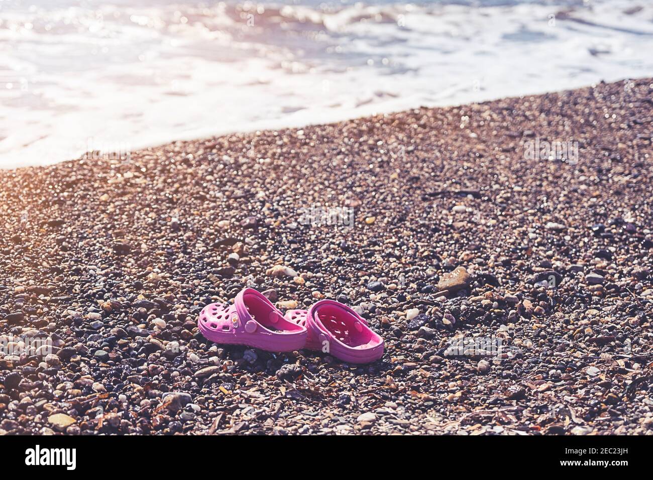 Little girl's rubber slippers on the beach at sunrise Stock Photo - Alamy